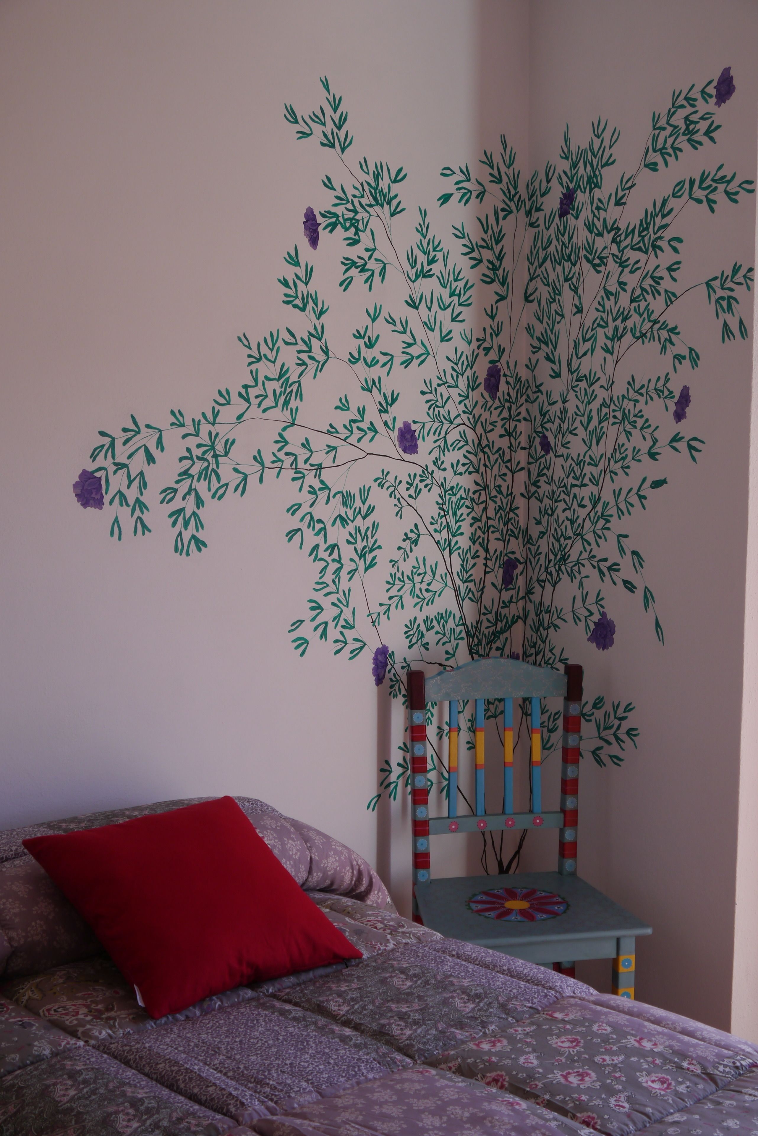Um quarto com uma cama, uma cadeira e um enfeite na parede.