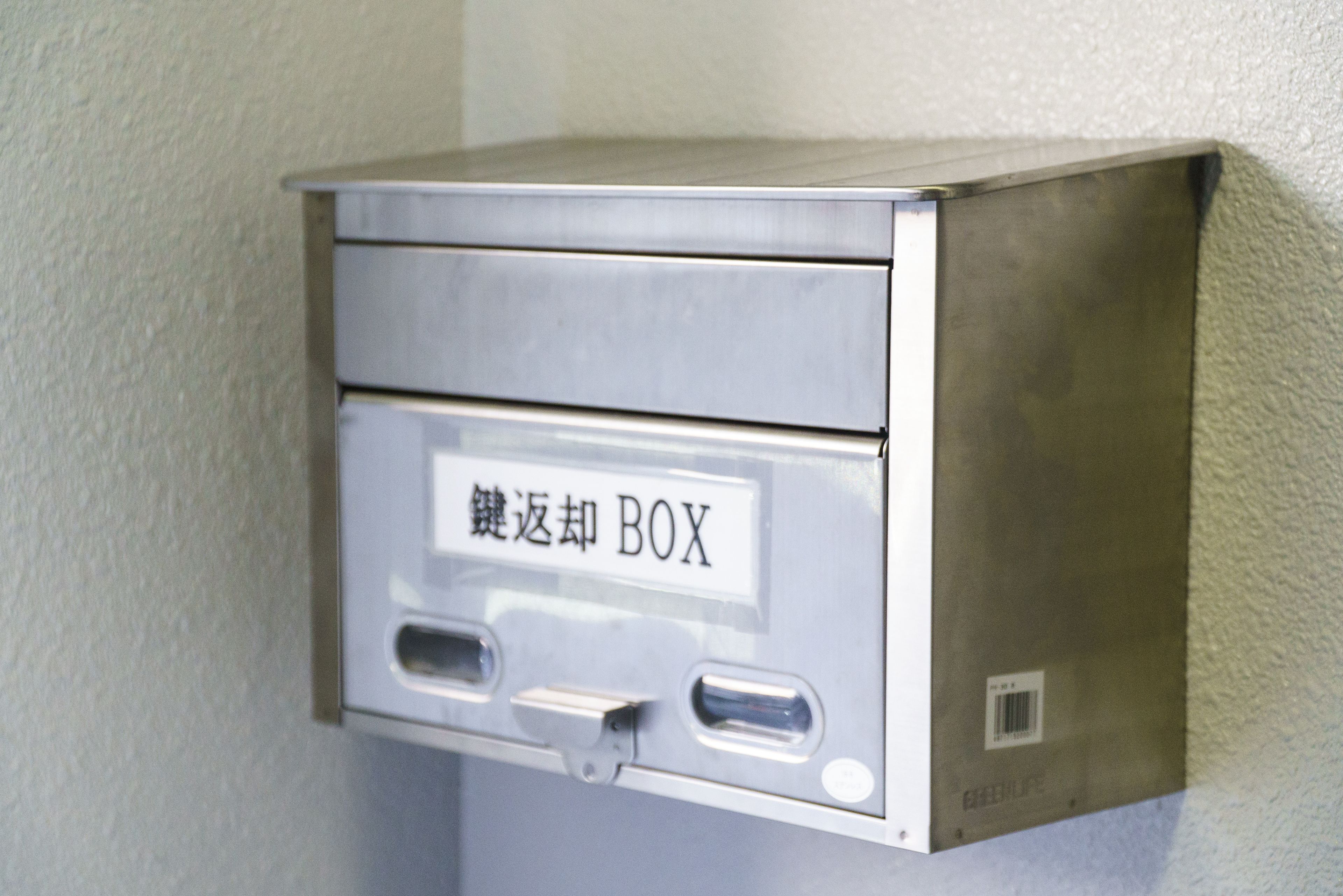 Uma caixa metálica com uma etiqueta que diz 'Box' em inglês e outro idioma.