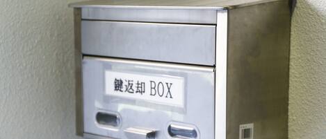 Uma caixa metálica com uma etiqueta que diz 'Box' em inglês e outro idioma.