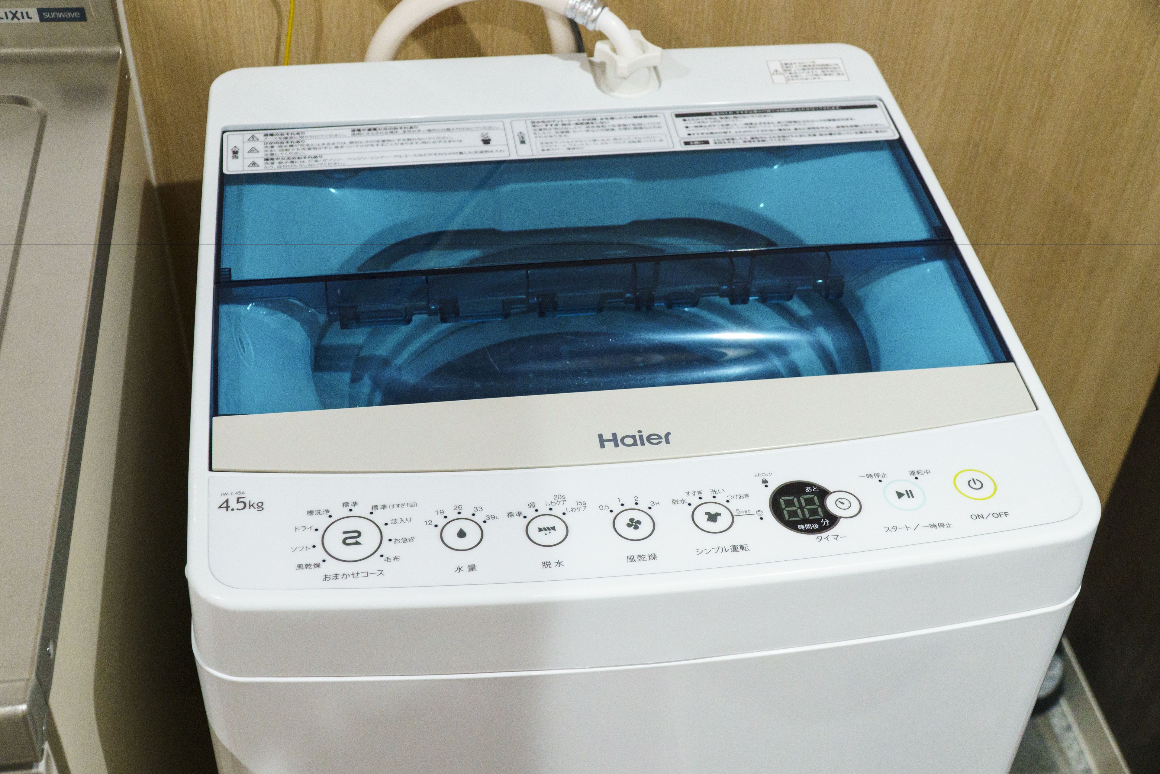 Máquina de lavar roupa Haier branca com porta transparente, painel de controle com várias configurações e etiqueta indicando capacidade de 4,5kg.