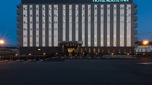 Um hotel com vários andares, fachada moderna, entrada destacada e placa com o nome no topo.