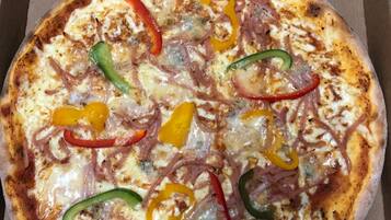 Uma pizza dentro de uma caixa de papelão.