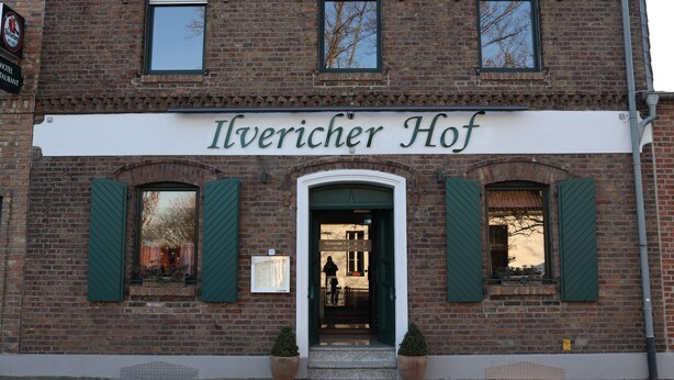 Um edifício de tijolos com uma placa que diz "Ilvericher Hof".