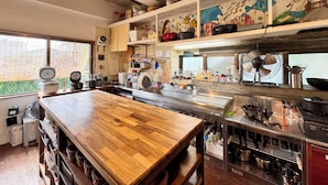 Uma cozinha com mesa de madeira, eletrodomésticos de aço inoxidável e janela com vista.