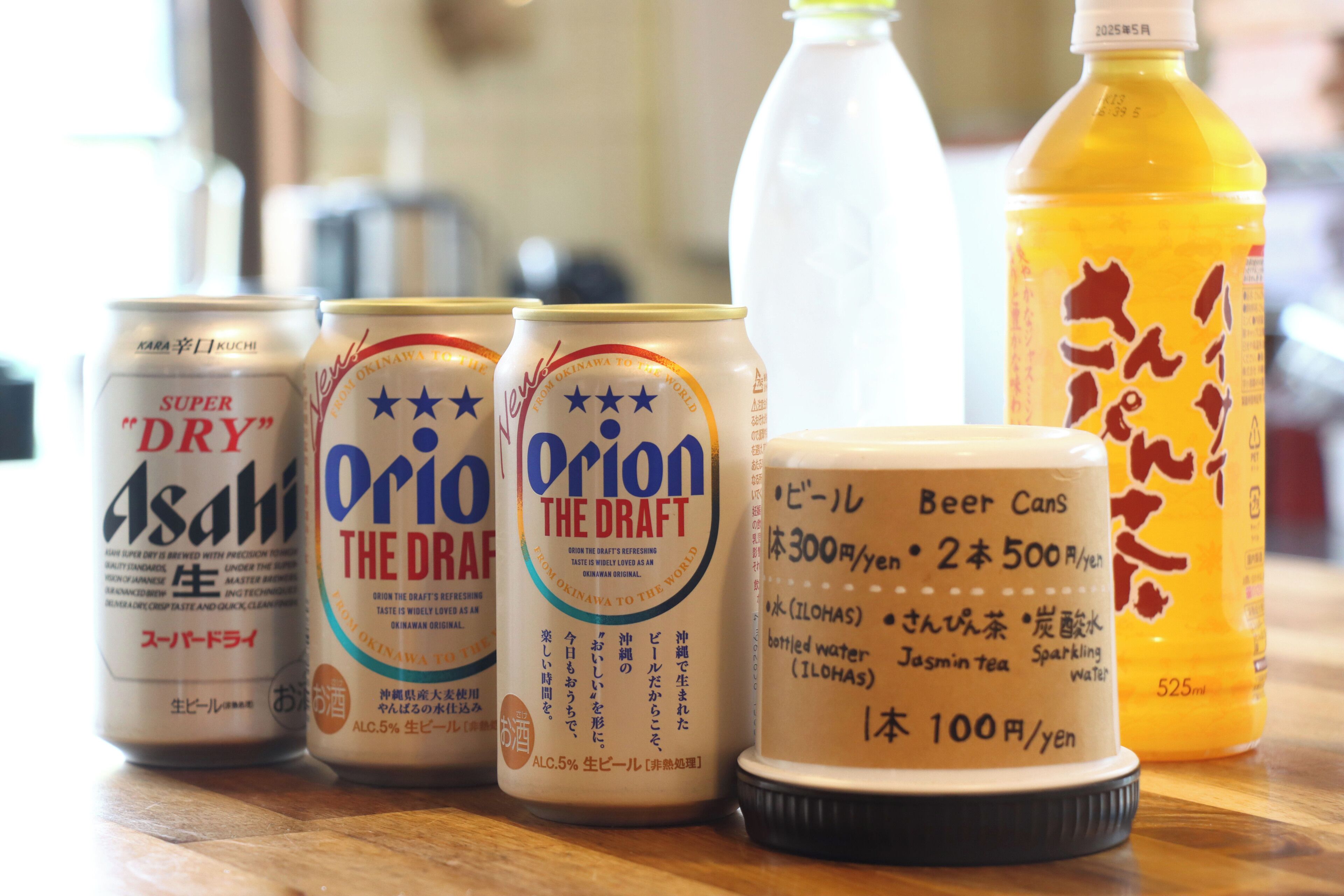 Diversas latas e garrafas de bebidas sobre uma mesa.