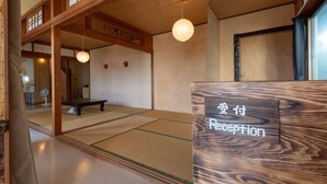 Um quarto japonês tradicional com tatames, portas deslizantes de madeira e um letreiro de recepção.