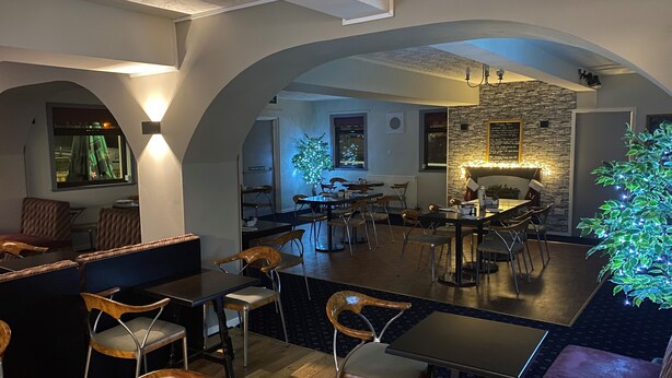 Um interior moderno com área de jantar, cozinha e espaço para sentar.