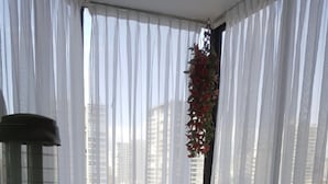 Uma varanda com mesa, cadeiras, aquecedor e planta pendente.