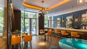Uma área de bar moderna com mesa de vidro, banquetas e balcão com resfriador de vinhos.