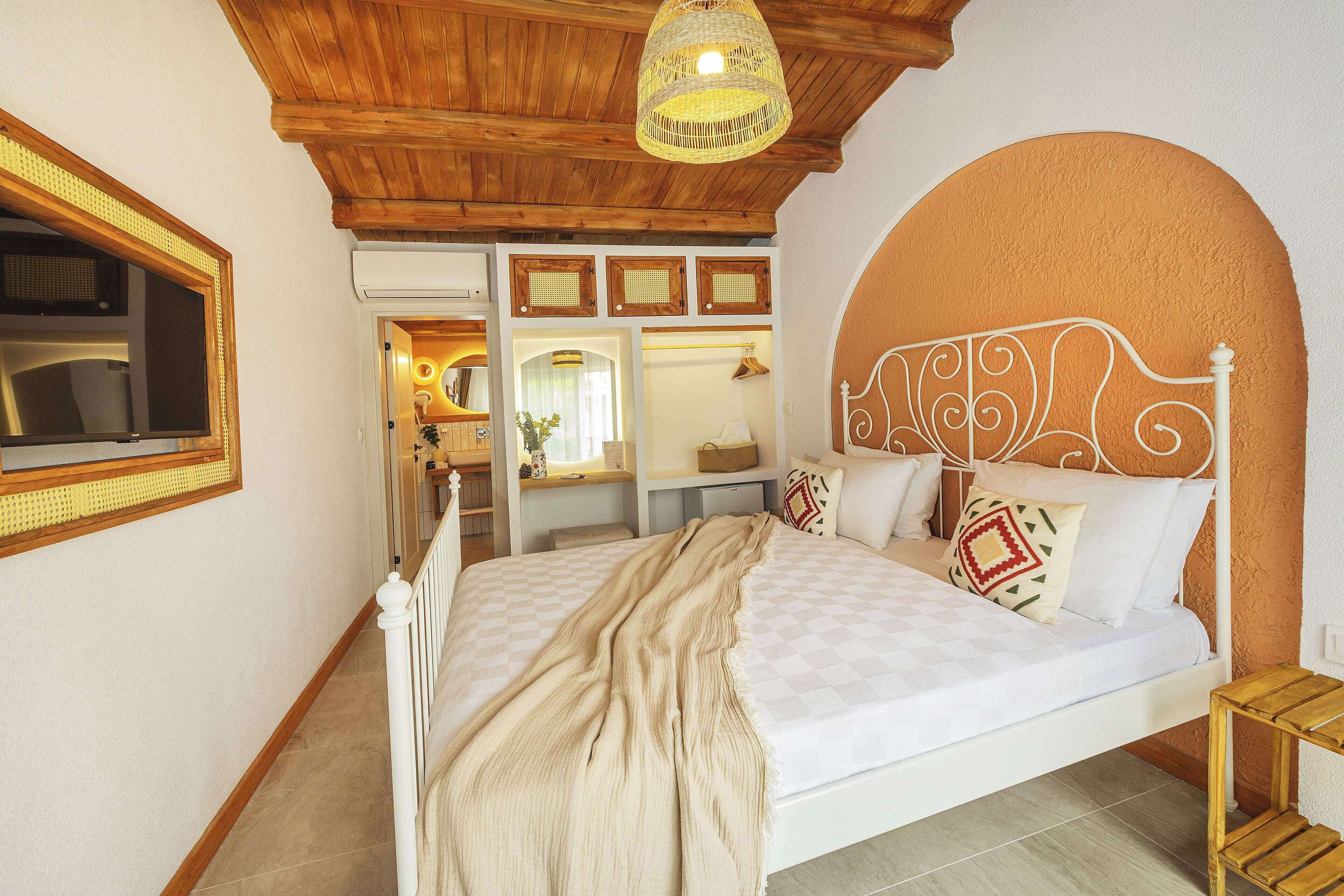 Quarto com cama, teto de madeira e luminária pendente.