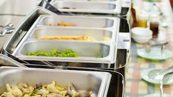 Buffet com diversas estações de comida, incluindo saladas, carnes e bebidas.