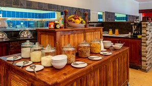 Um balcão de café da manhã com diversos alimentos e acompanhamentos.