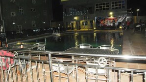 Área de piscina com palco e assentos ao fundo.