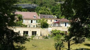 Um bairro residencial com casas de pedra, um gramado e um pequeno lago.