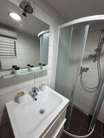 Duplex conforto | Banheiro | Chuveiro, secador de cabelo, toalhas de banho, papel higiênico