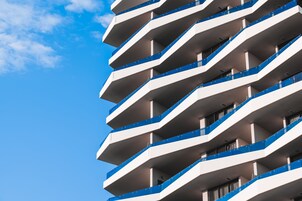 Um edifício de vários andares com um design de varanda em zigue-zague, apresentando uma série de varandas em cada pavimento.