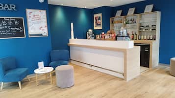 Uma área de bar com paredes azuis, um balcão e assentos.