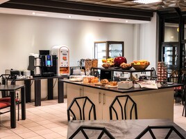 Uma cozinha moderna com cafeteira, potes de frutas e diversas opções para o café da manhã.