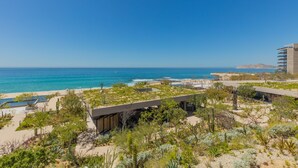 Um resort com área de piscina, praia e vista para o oceano.