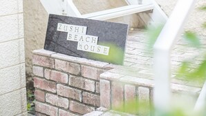Uma escadaria leva a uma casa com uma placa que diz "Zushi Beach House".
