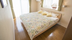 Quarto com cama grande, janela com cortinas, decoração náutica e ar-condicionado fixado na parede.