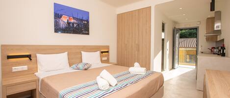 Quarto de hotel moderno com uma cama grande, cabeceira de madeira e uma pintura de paisagem urbana na parede.