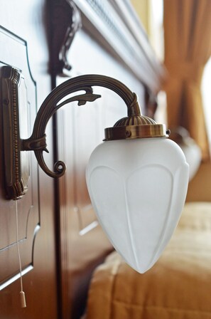 Arranjo de luz fixado na parede com cúpula branca e suporte em latão.