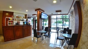 Uma área de bar com balcão, cadeiras e mesas.