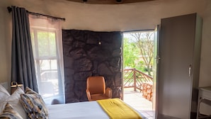 Quarto com cama, cadeira e vista para o exterior.