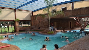 Piscina interna com vários níveis e uma parede de pedra.