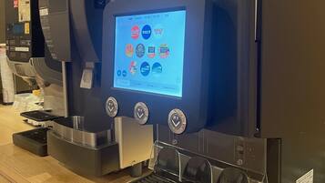 Máquina de café com visor digital, dosador de café e bandeja para copos.