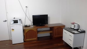 Quarto Deluxe, várias camas, frigorífico e micro-ondas | Sala de estar | TV de ecrã plano 