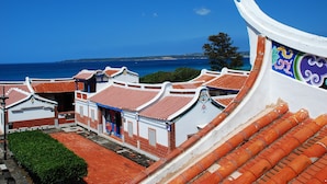 Um edifício tradicional com telhado curvo e vista para o oceano.