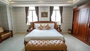 Quarto espaçoso com uma cama grande, um guarda-roupa de madeira e um espaço para sentar.