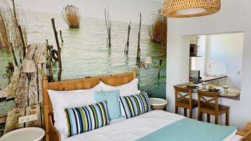 Quarto com cama, mesas de cabeceira, escrivaninha e espelho.