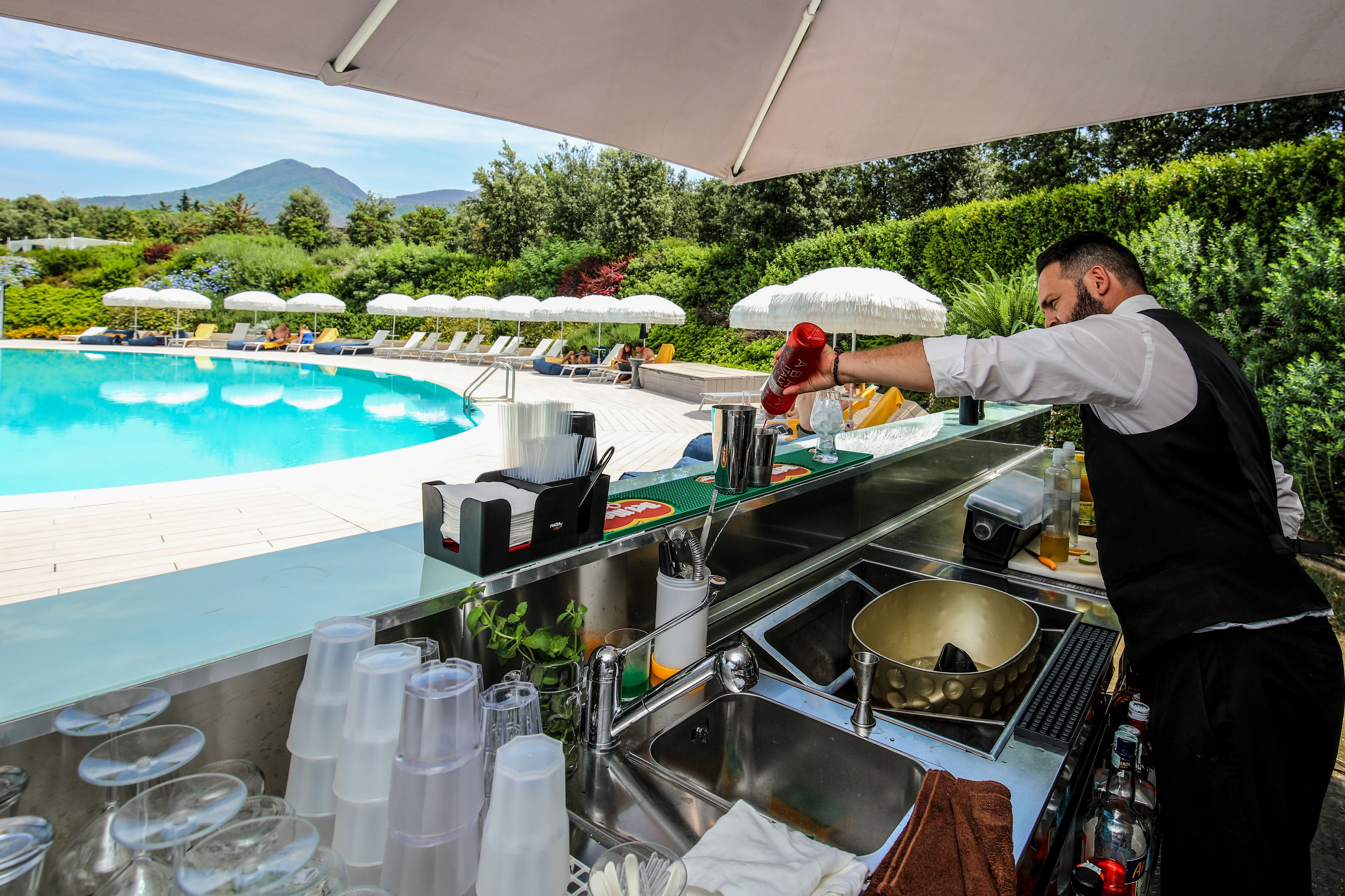 Bar à beira da piscina com vista para uma piscina e montanhas.