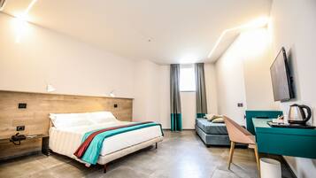 Quarto de hotel moderno com cama, escrivaninha e televisão.