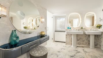 Uma casa de banho moderna com um espelho grande, duas pias e um lavatório com um vaso decorativo.