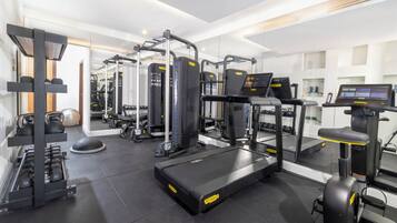 Uma academia moderna com diversos equipamentos de exercício, incluindo esteiras, aparelhos de musculação e pesos livres.
