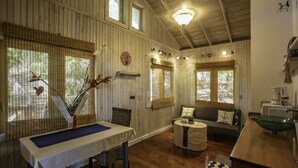 Um quarto acolhedor com piso de madeira, um sofá, uma mesa e uma mesinha redonda.