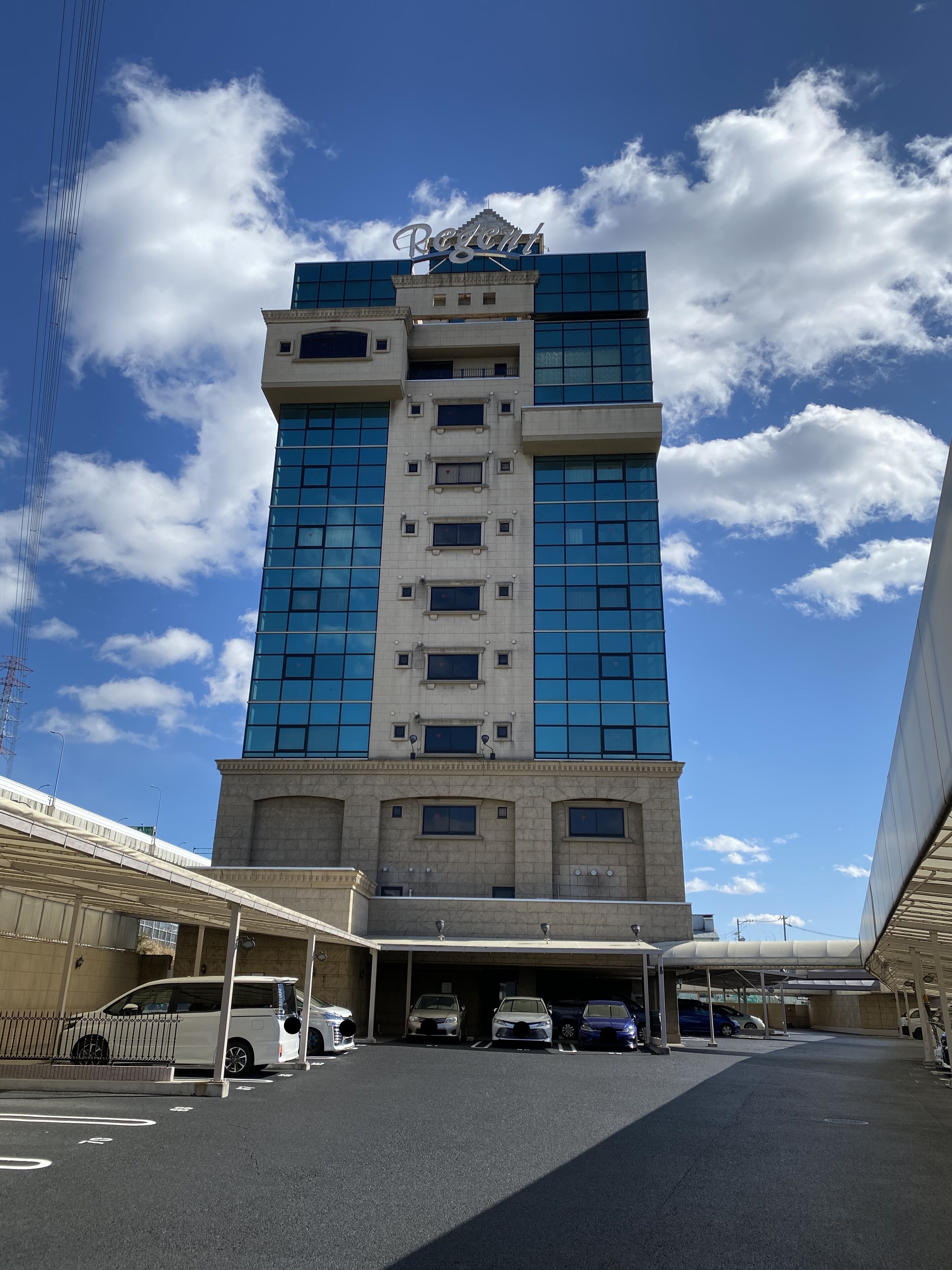 Um hotel alto com fachada de vidro moderna e a placa 