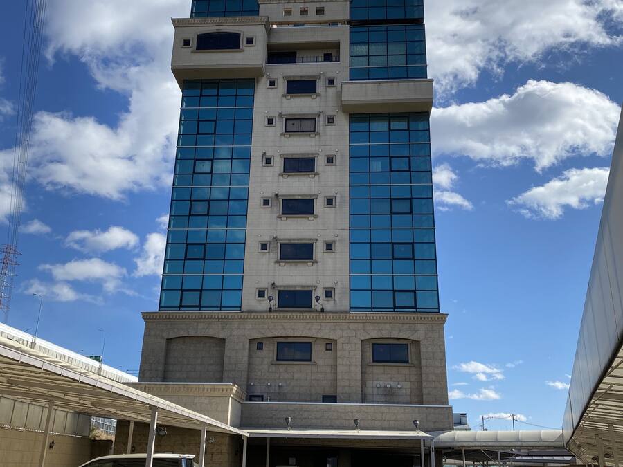 Um hotel alto com fachada de vidro moderna e a placa