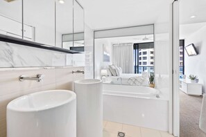 Uma casa de banho moderna com uma grande pia, uma banheira e um espelho.