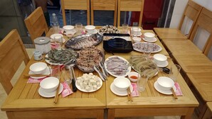 Uma mesa de jantar posta com diversos pratos, talheres e copos.