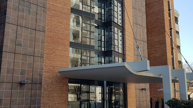 Um edifício moderno com fachada de tijolos e grandes janelas.