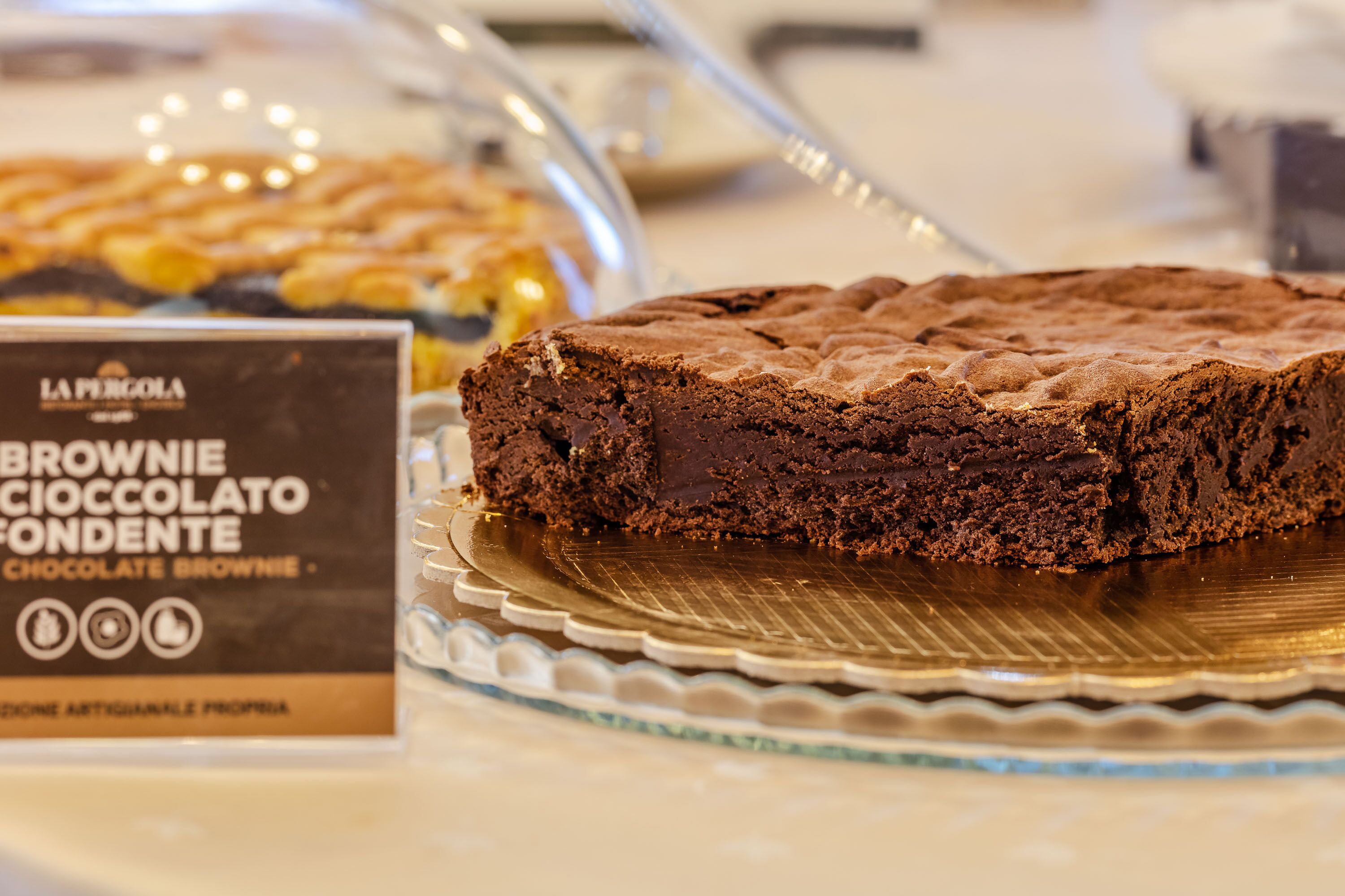 Um brownie em um prato de vidro com uma etiqueta na frente.