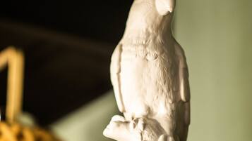 Uma escultura de pássaro branco sobre um suporte.