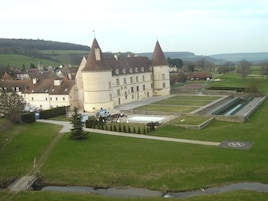 Um grande edifício histórico com várias torres e um gramado bem cuidado.