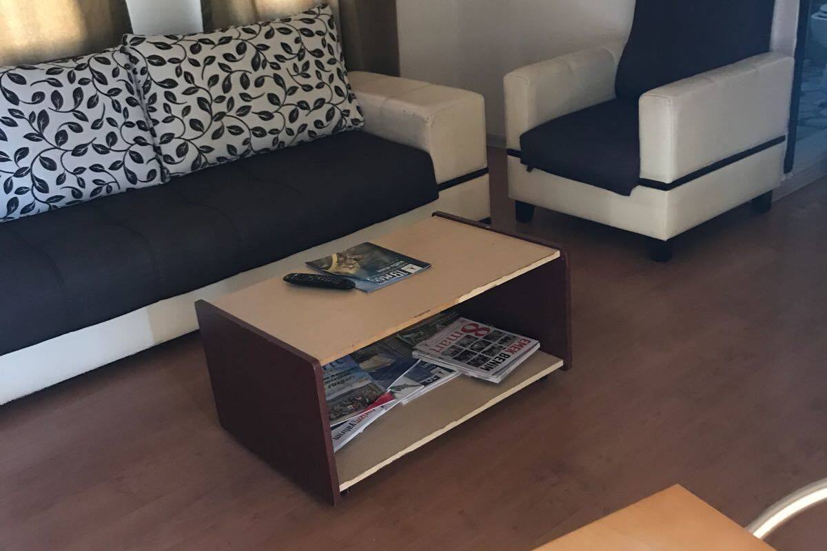 Uma sala de estar moderna com sofá, poltrona e mesa de centro.