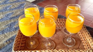 Uma bandeja com seis copos de sumo de laranja sobre um tapete tecido.